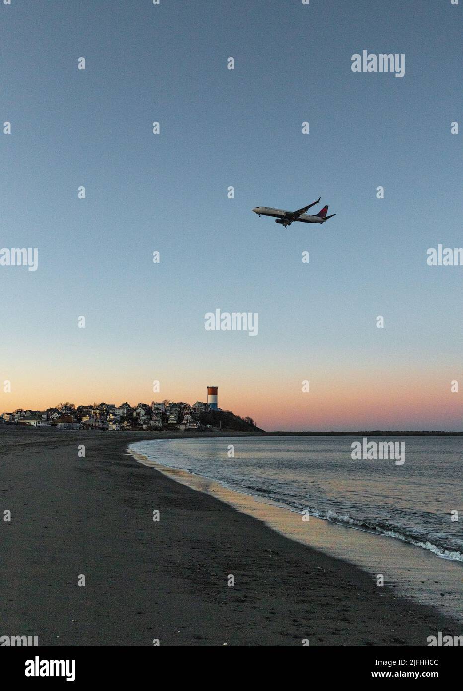 A vertical Delta Air Lines airplane flying in the sky at sunset ...