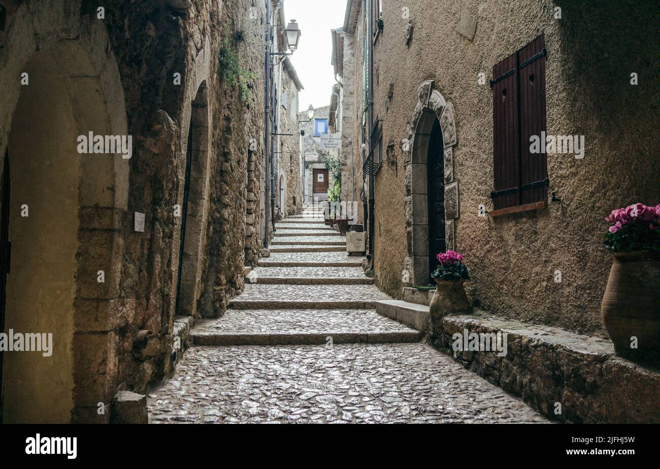 A narrow alley with a stairway and old stone buildings Stock Photo - Alamy