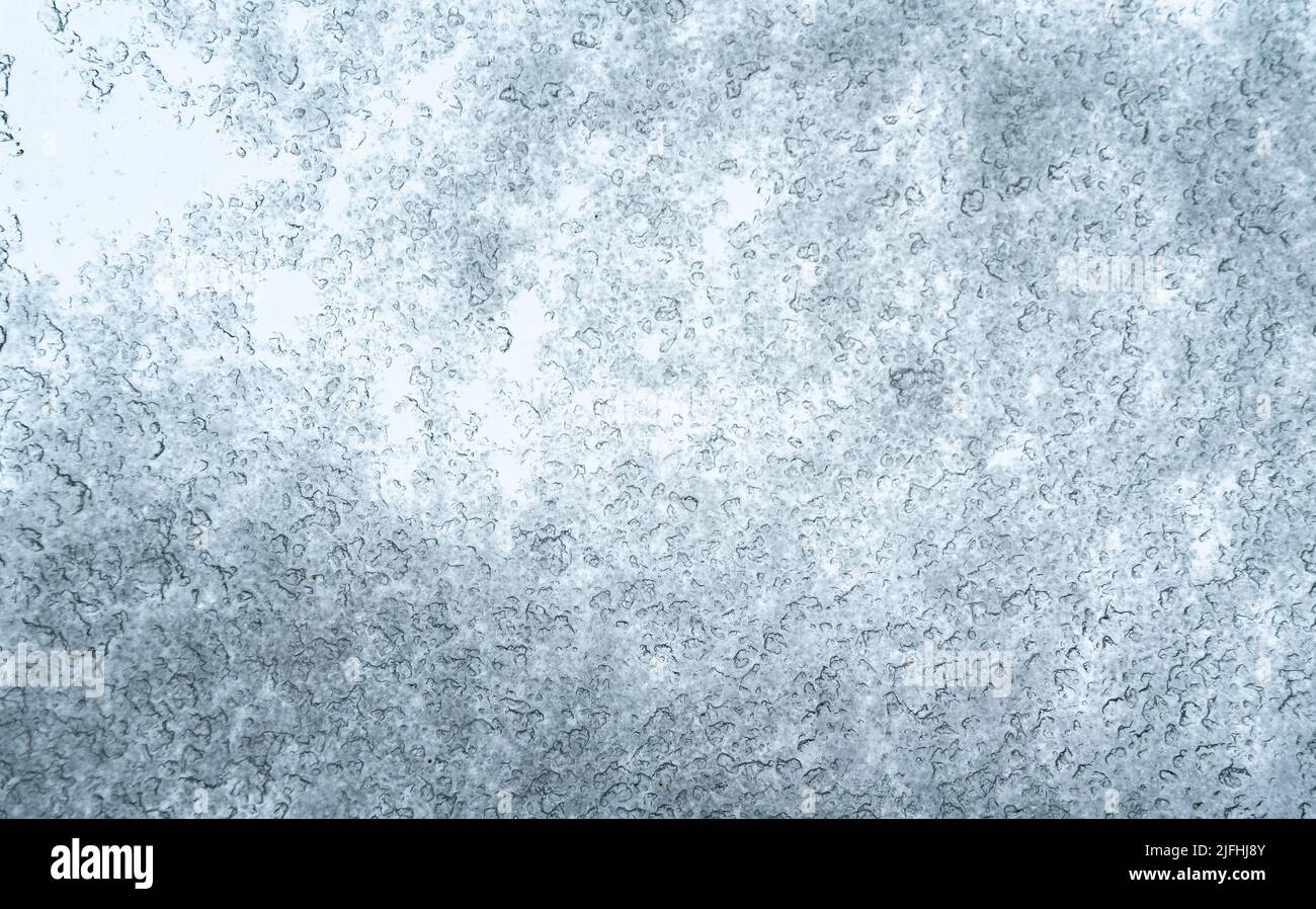 Snow creating texture on the glass. Structure of snow flakes and ice ...