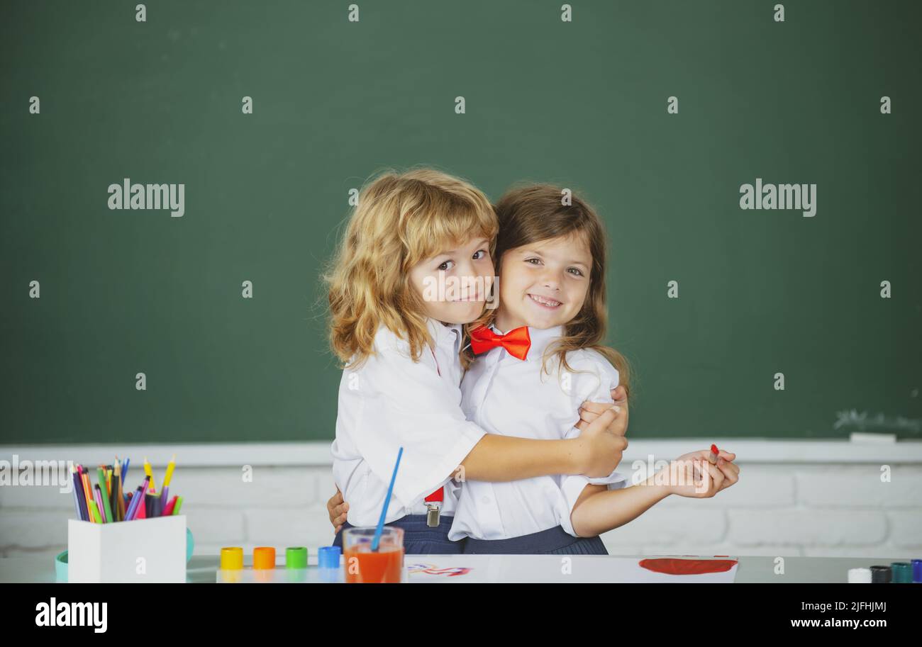 School friends hugging. Two school kids, girl and boy holding hands ...