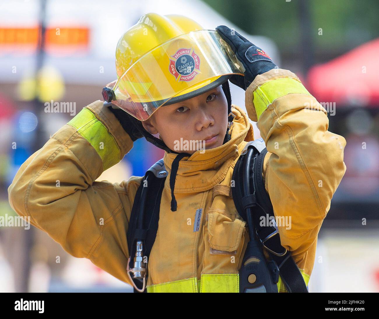 A firefighter adjusts her helmet as she compete’s in the Firefit ...