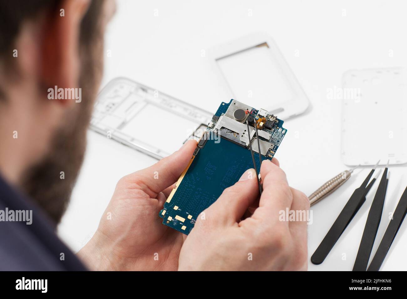 Repairman disassembling smartphone with tweezers Stock Photo - Alamy