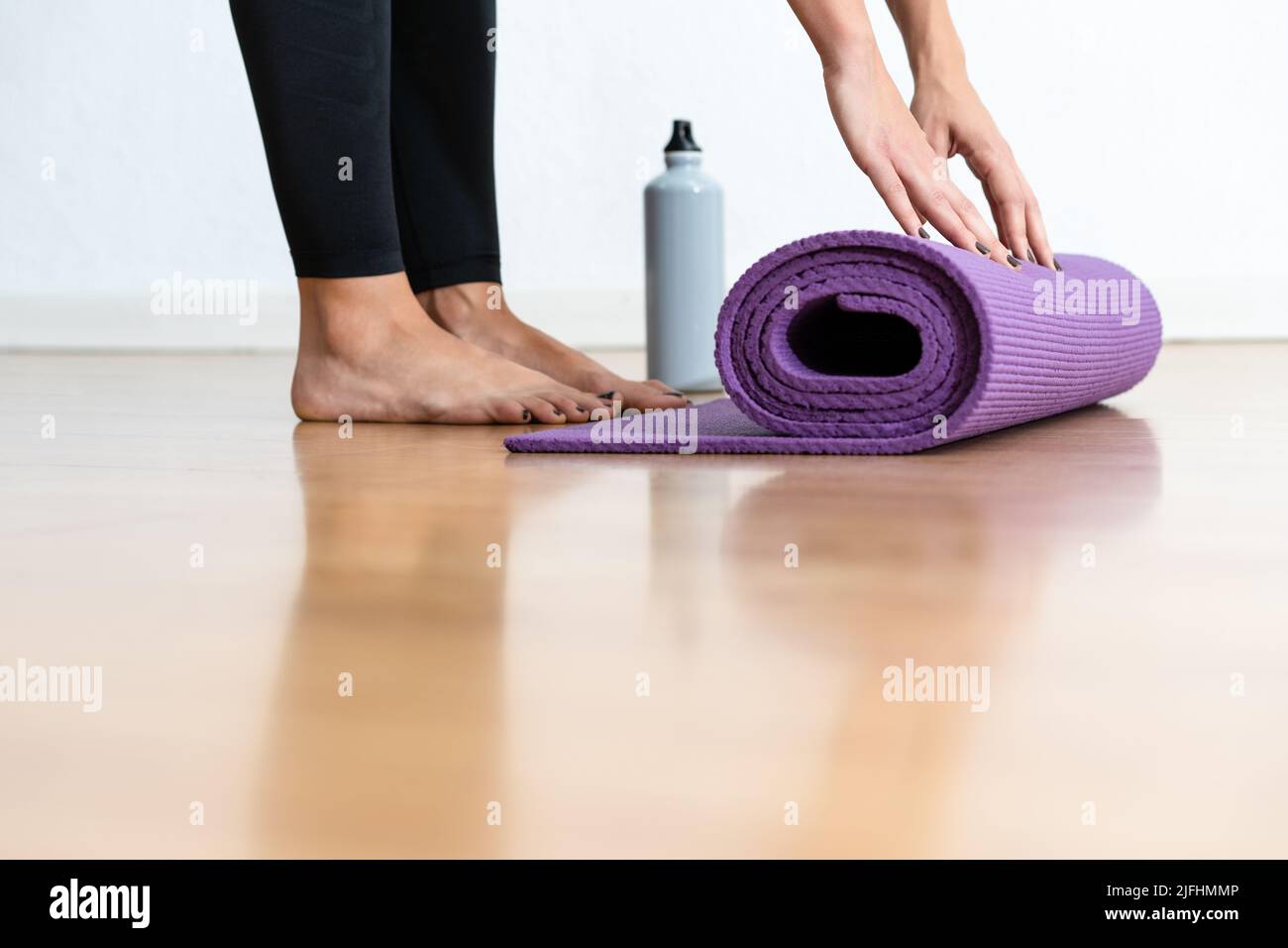 Closeup of a woman preparing a yoga class. Detail of her feet, hands ...
