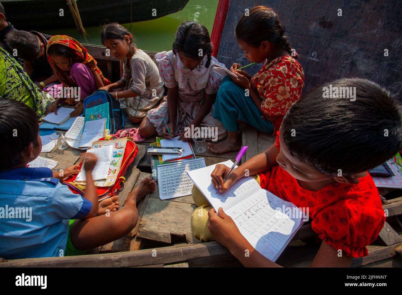 Gypsy children attend at class at a floating school on a canal at ...