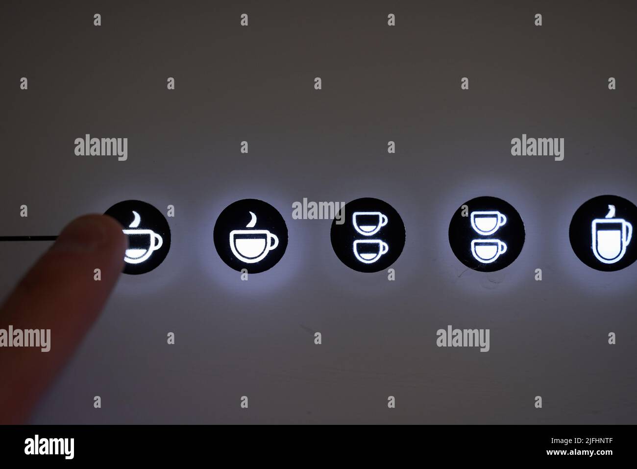 Finger pressing espresso button in automatic coffee machine. High ...