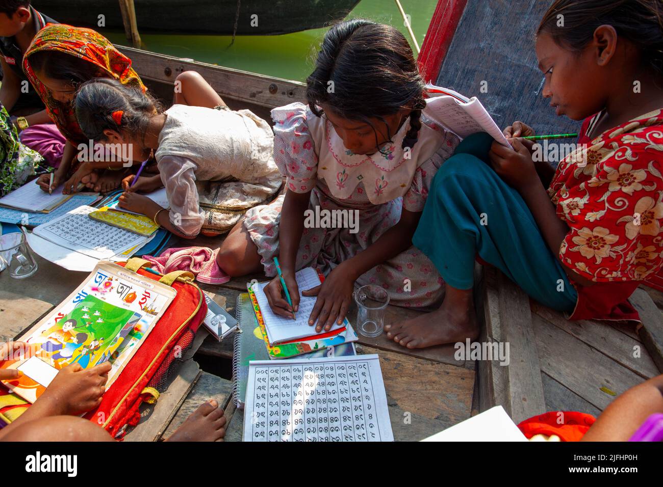 Gypsy children attend at class at a floating school on a canal at ...