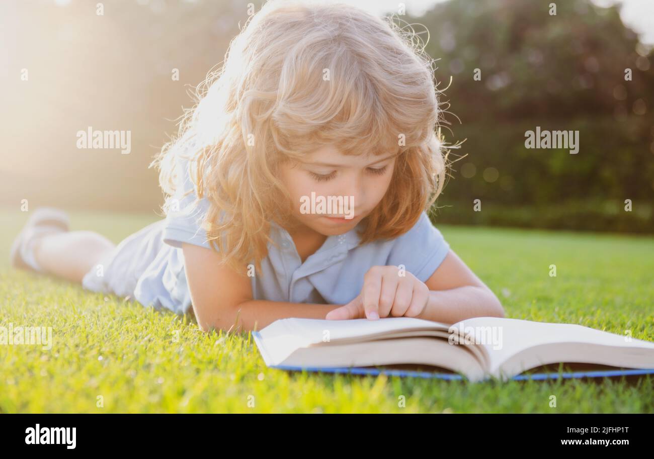 Smart clever Kids. Kid boy reading interest book in the garden ...