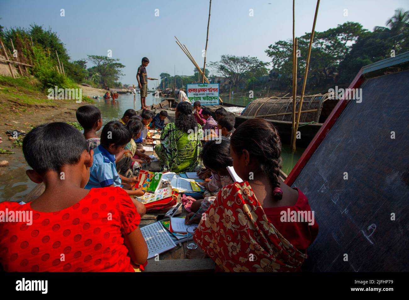 Gypsy children attend at class at a floating school on a canal at ...