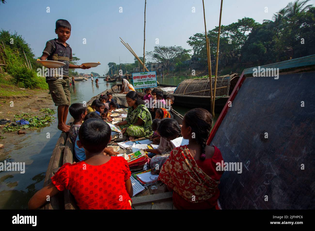 Gypsy children attend at class at a floating school on a canal at ...