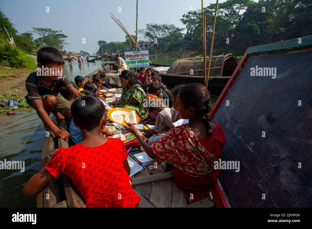 Gypsy children attend at class at a floating school on a canal at ...