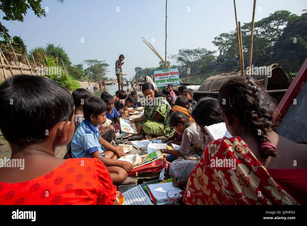 Gypsy children attend at class at a floating school on a canal at ...