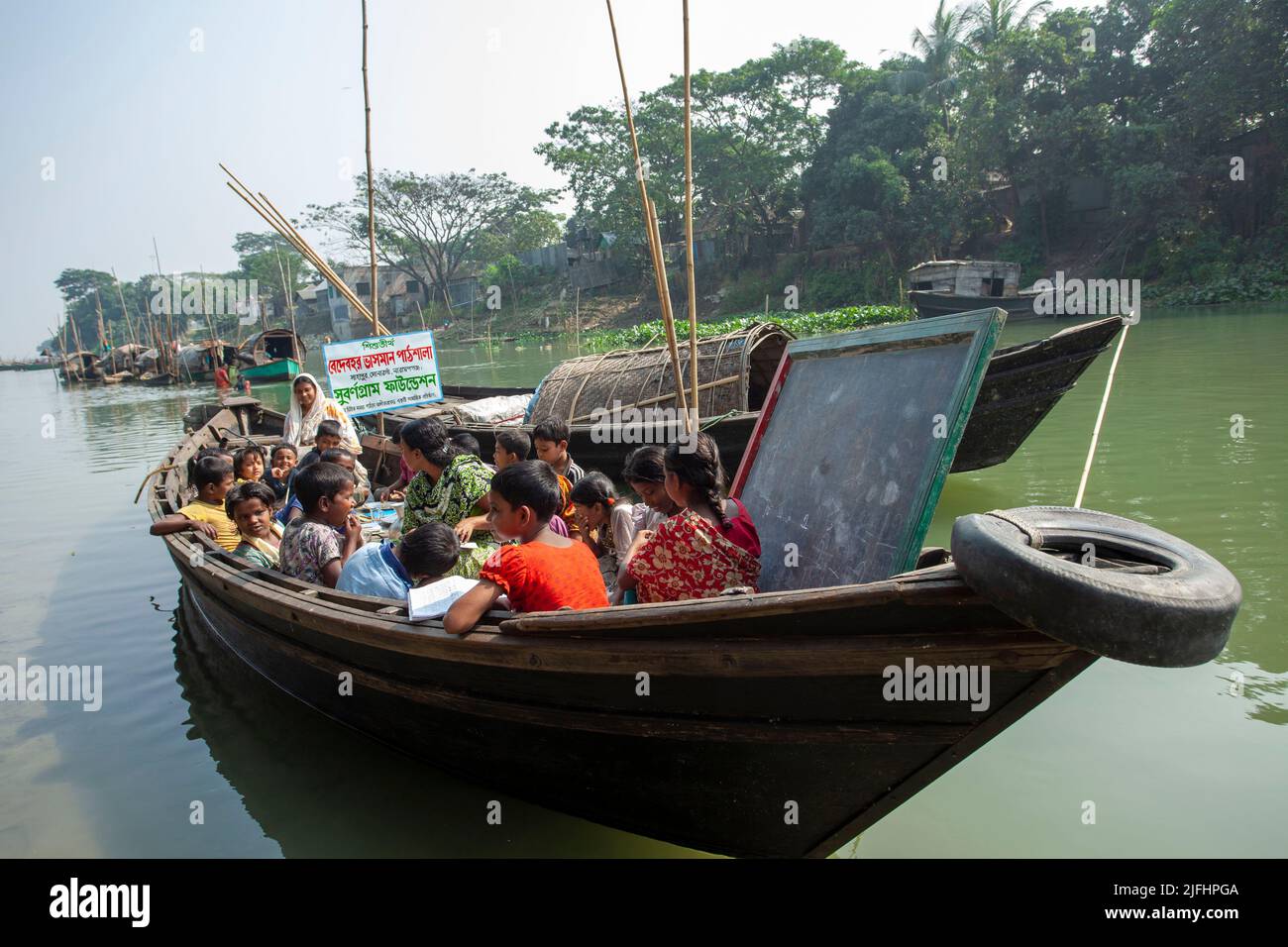 Gypsy children attend at class at a floating school on a canal at ...