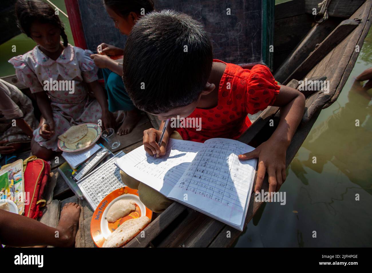 Gypsy children attend at class at a floating school on a canal at ...