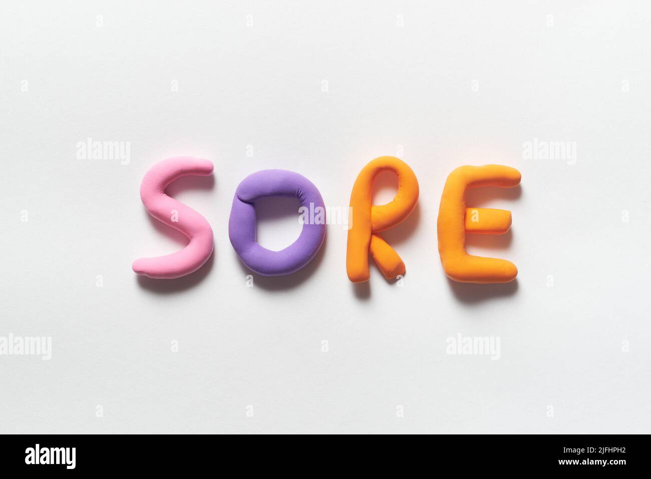 Sore word formed of colored plasticine on white backdrop Stock Photo ...