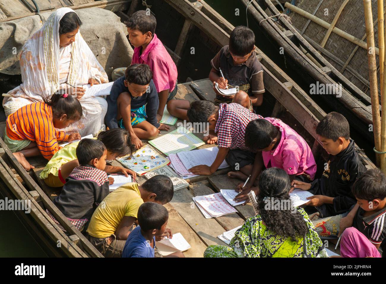 Gypsy children attend at class at a floating school on a canal at ...