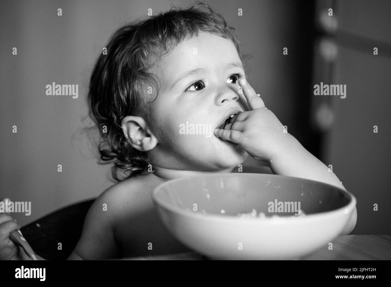 Portrait of cute Caucasian child kid with spoon. Hungry messy baby with ...