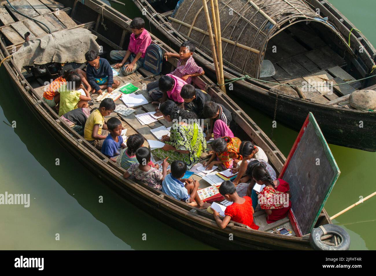 Gypsy children attend at class at a floating school on a canal at ...