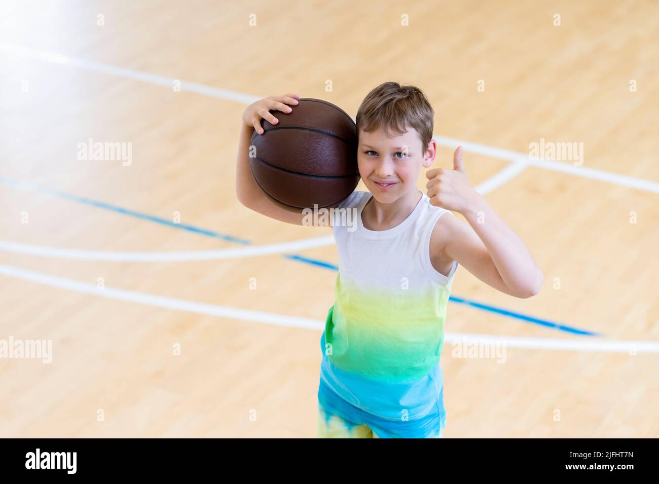 School kid playing basketball in a physical education lesson ...
