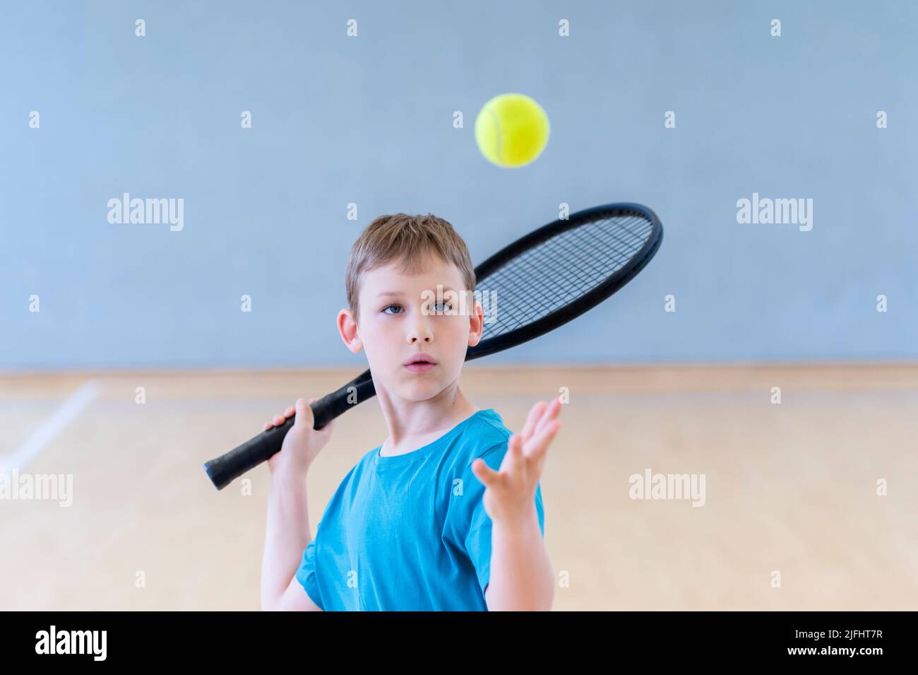 School kid playing tennis in a physical education lesson. Horizontal ...