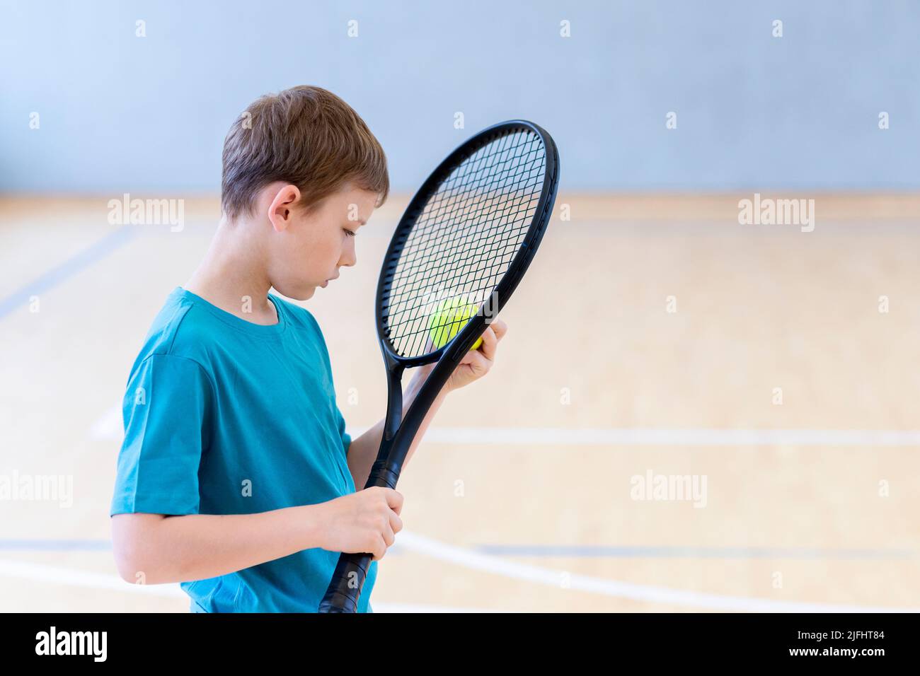 Sad disappointed boy with tennis racket and ball in a physical ...