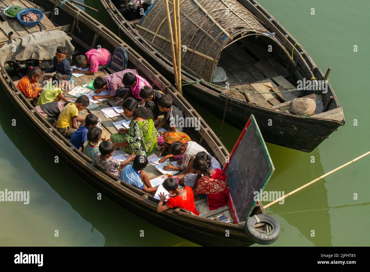 Gypsy children attend at class at a floating school on a canal at ...