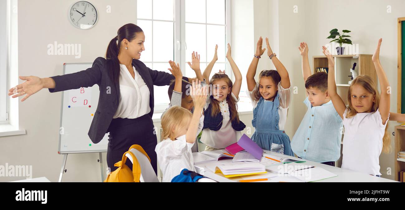 Happy school teacher and cheerful elementary students having fun in the ...
