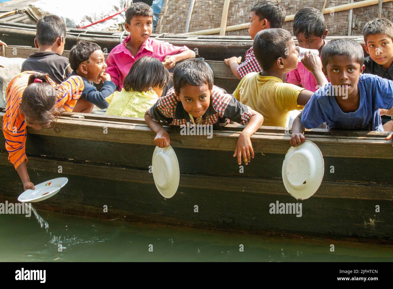 Gypsy children washing plates after taking meal at a floating school on ...