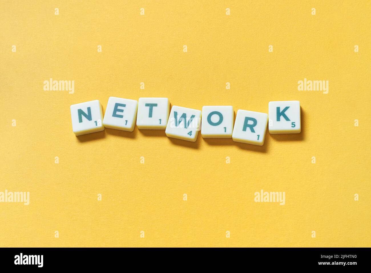 Network formed of scrabble elements on yellow background Stock Photo ...