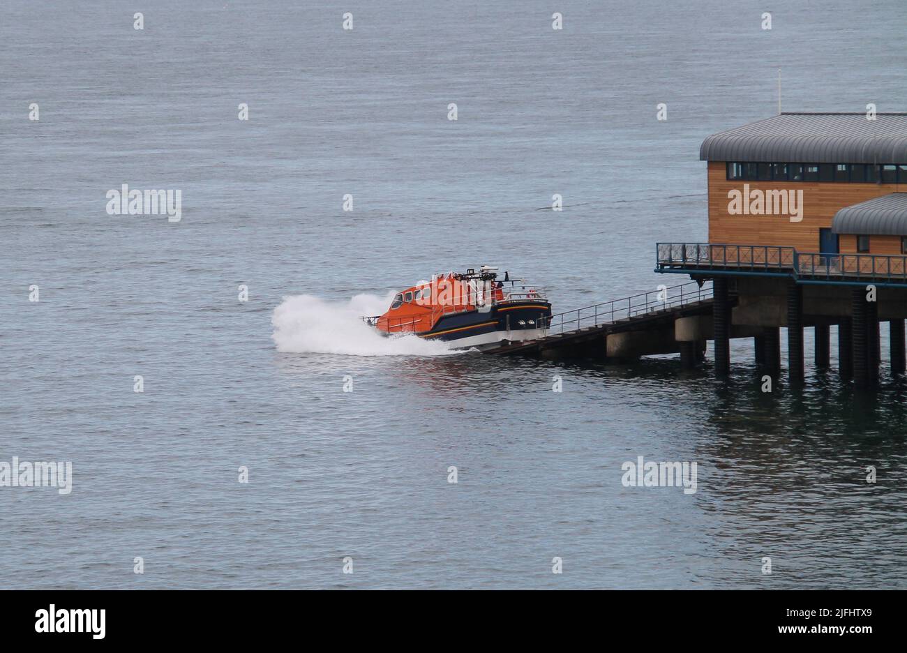 The Launch of a Rescue Lifeboat From a Pier Slipway Stock Photo - Alamy