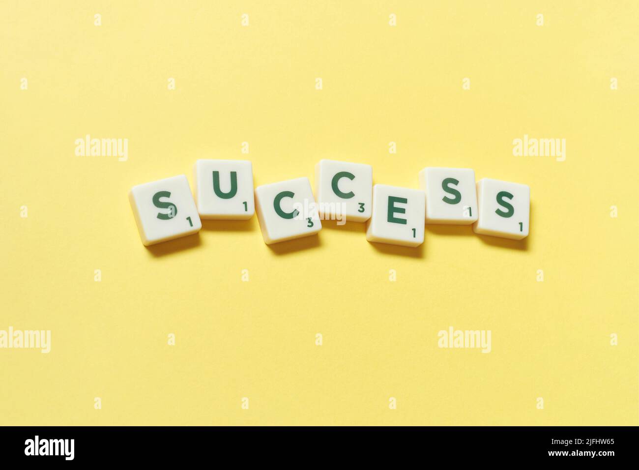 Success formed of scrabble blocks on yellow background Stock Photo - Alamy