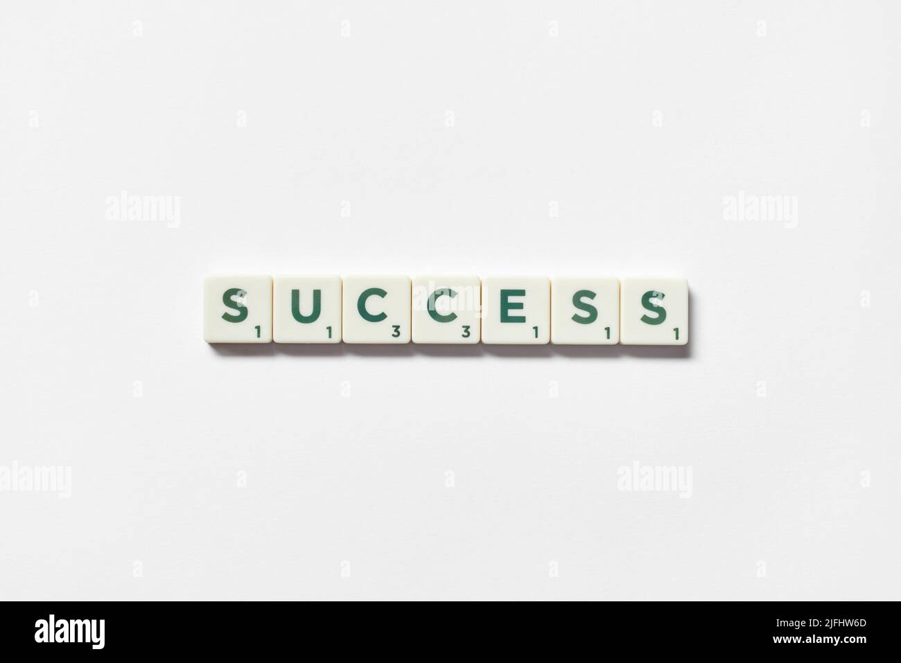 Success formed of scrabble tiles on white background Stock Photo - Alamy