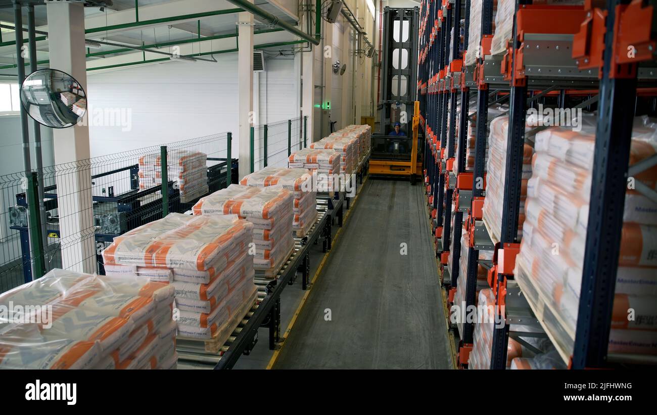 Arrangement of goods on huge shelves. Creative. A man walks and ...