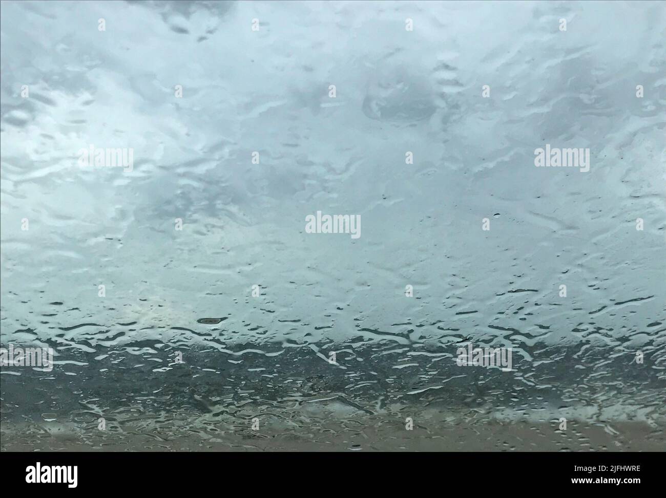 Close up glass with raindrops. Blurred view looking out through glass ...