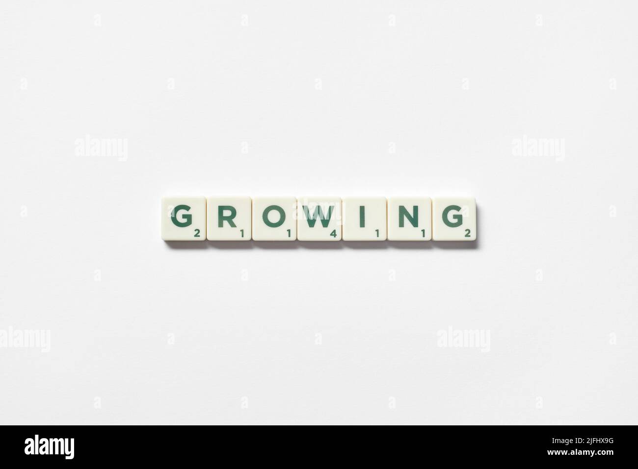 Growing formed of scrabble blocks on white background Stock Photo - Alamy