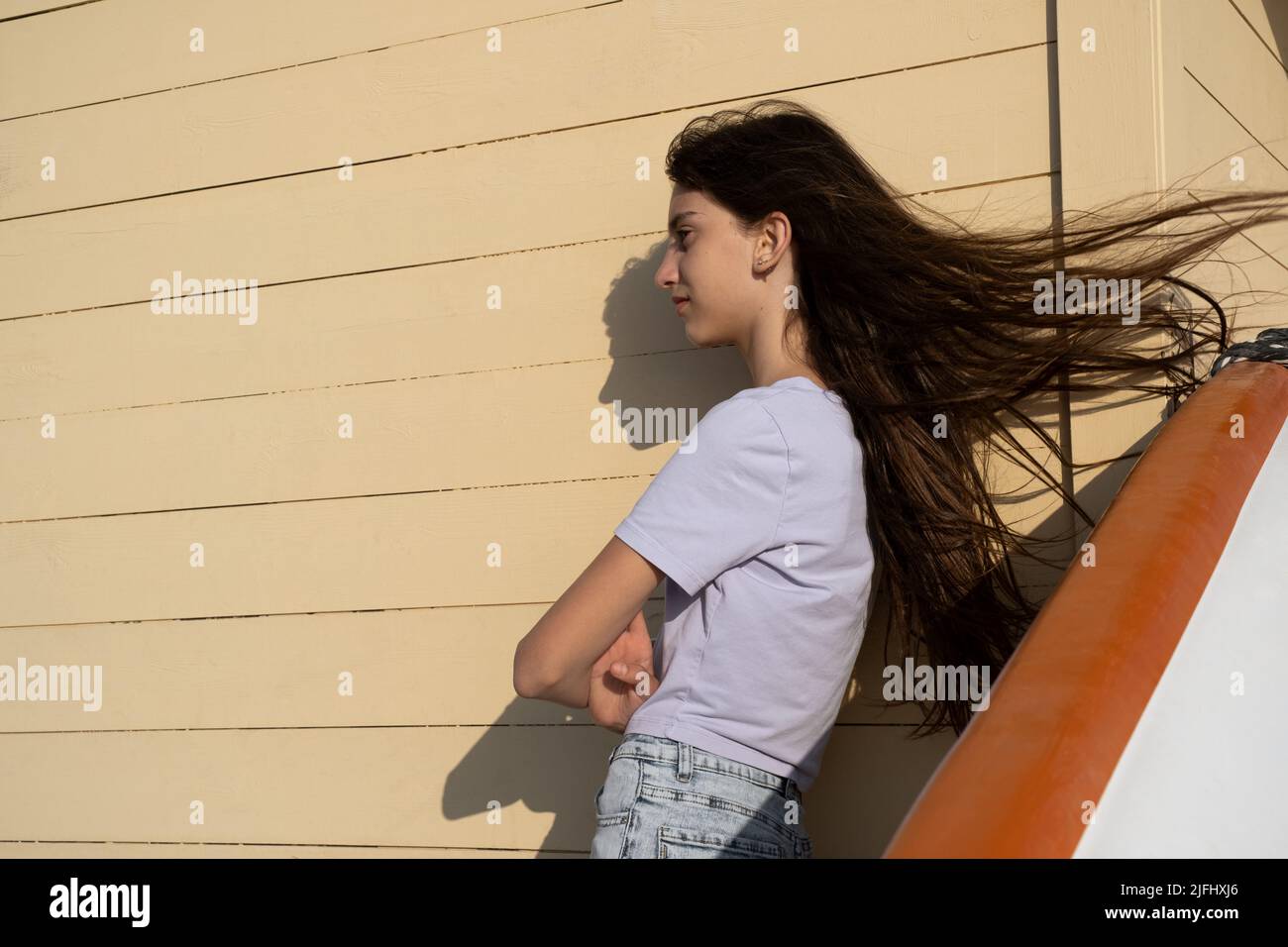 A young israeli woman with flowing hair stands leaning against a ...