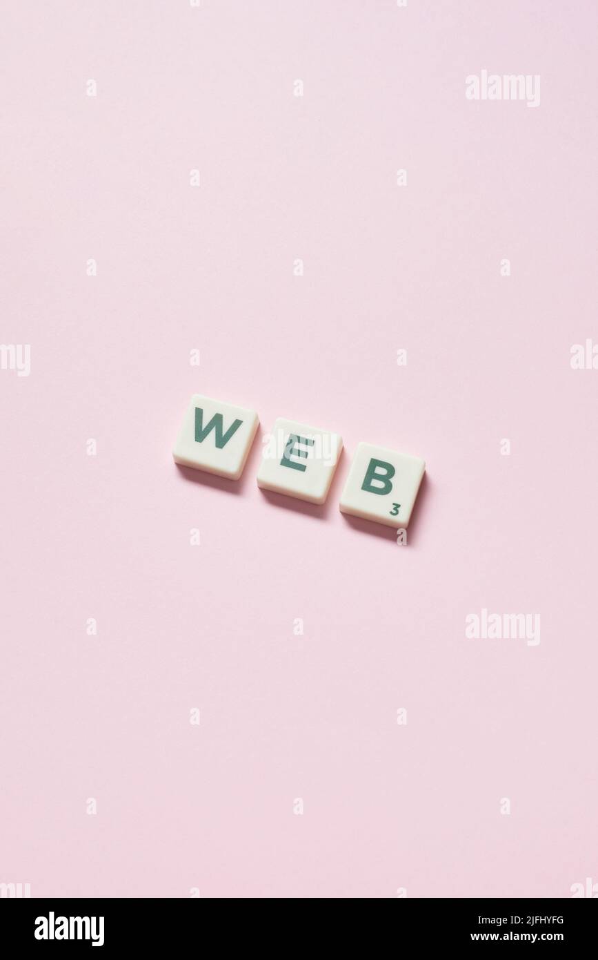 Web formed of scrabble tiles on pink background Stock Photo - Alamy
