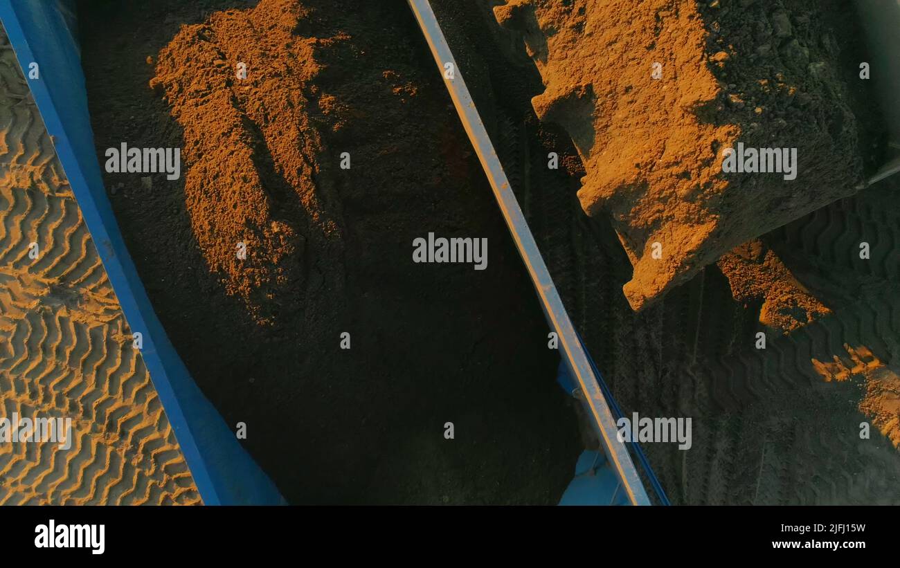 Excavator removing sand into dump truck. Scene. Top view of excavator ...