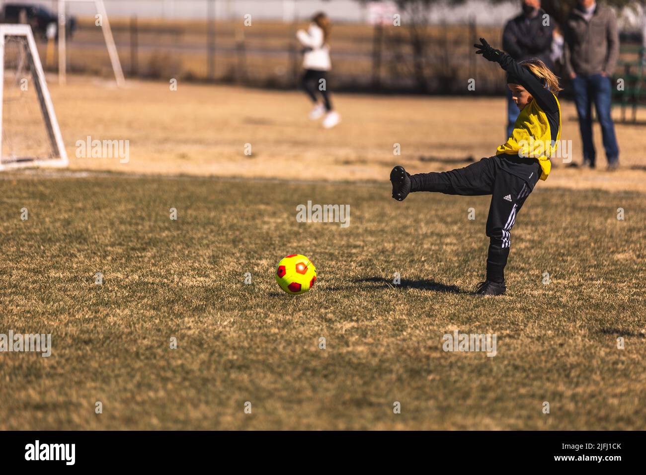 A young soccer player hitting a goal on a field Stock Photo - Alamy