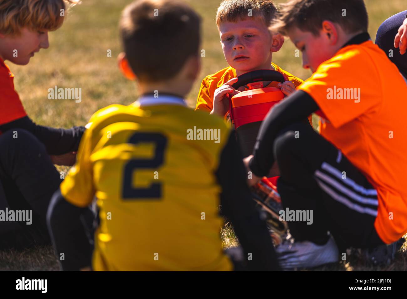 Young soccer players sitting on a field before the match Stock Photo ...