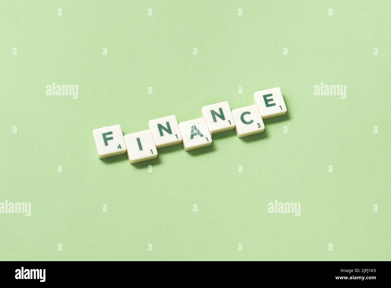 Finance formed of scrabble blocks on green background Stock Photo - Alamy