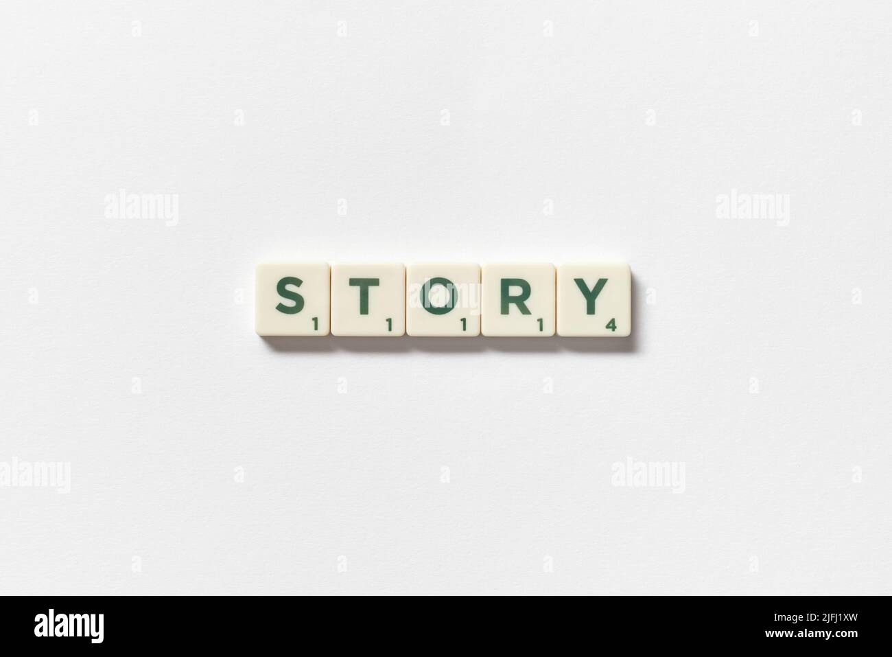 Story formed of scrabble tiles on white background Stock Photo - Alamy