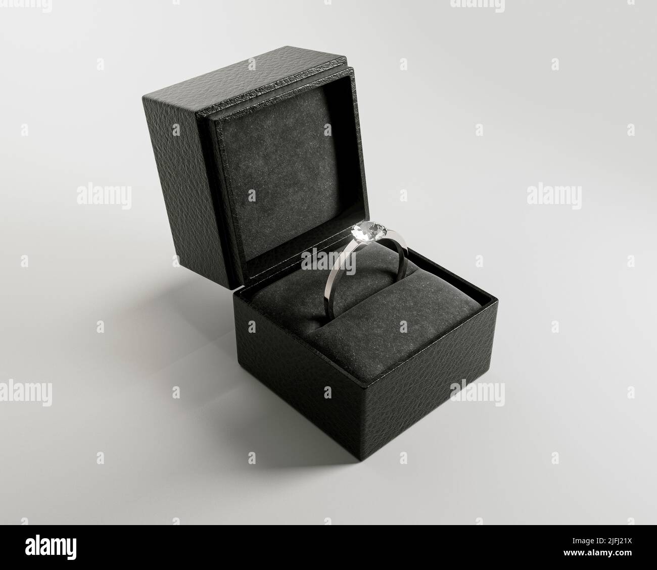 An open cube shaped black ring box with a silver engagement ring and ...