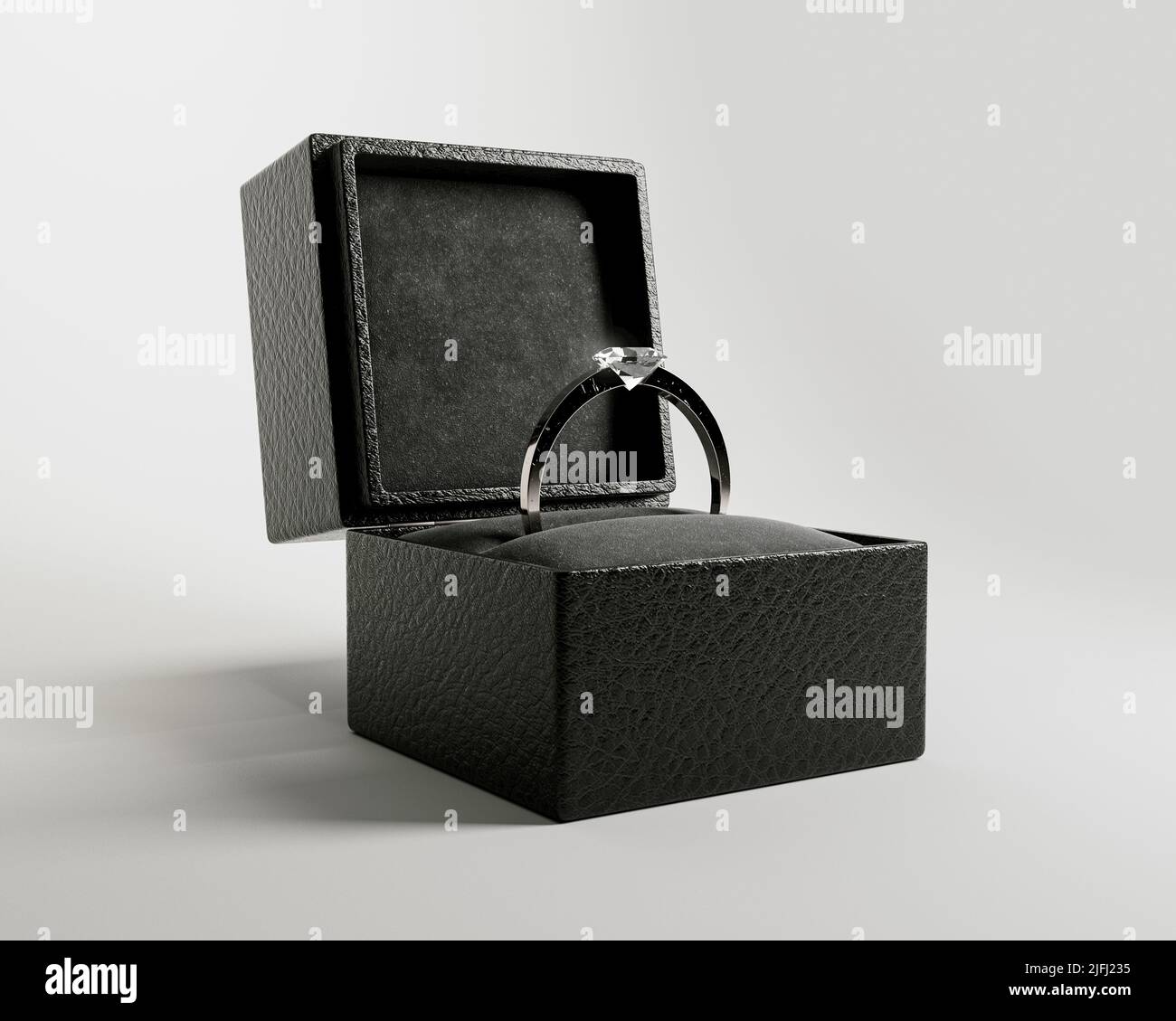 An open cube shaped black ring box with a silver engagement ring and ...