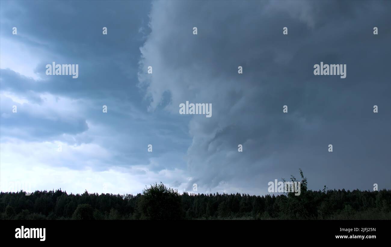 Storm or rain clouds hanging above green forest and meadow. Creative ...