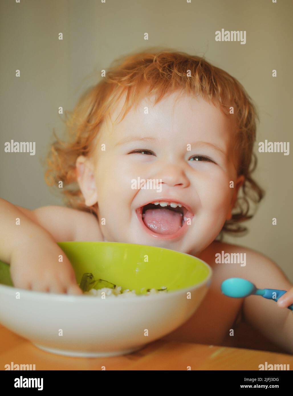 Launching child eat. Smiling baby eating food. Family, food, child ...