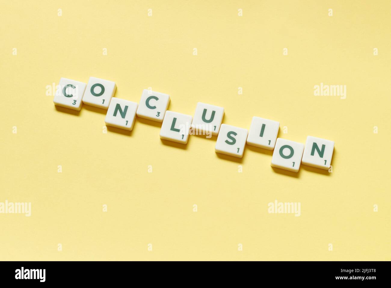 Conclusion formed of scrabble tiles on yellow background Stock Photo ...
