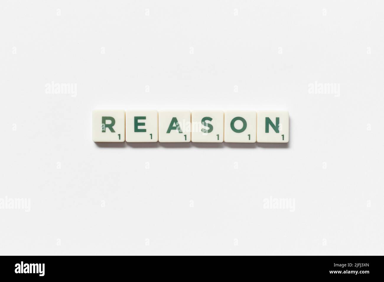 Reason formed of scrabble tiles on white background Stock Photo - Alamy