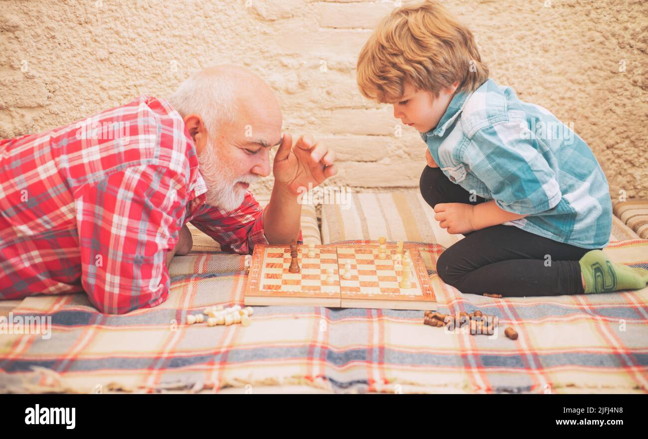 Senior man teaching his grandson to play chess. Handsome grandpa and ...