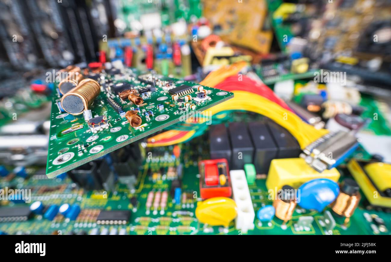 Circuit board on blur e-waste pile of discarded electric or computer ...