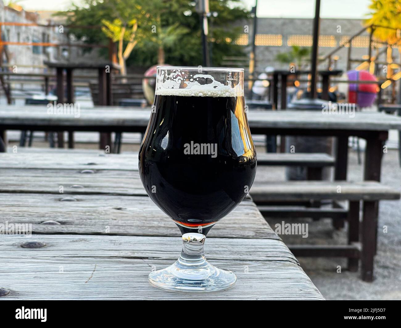 glass cup with craft beer from Cerveceria la Ruina dark, brown color on ...